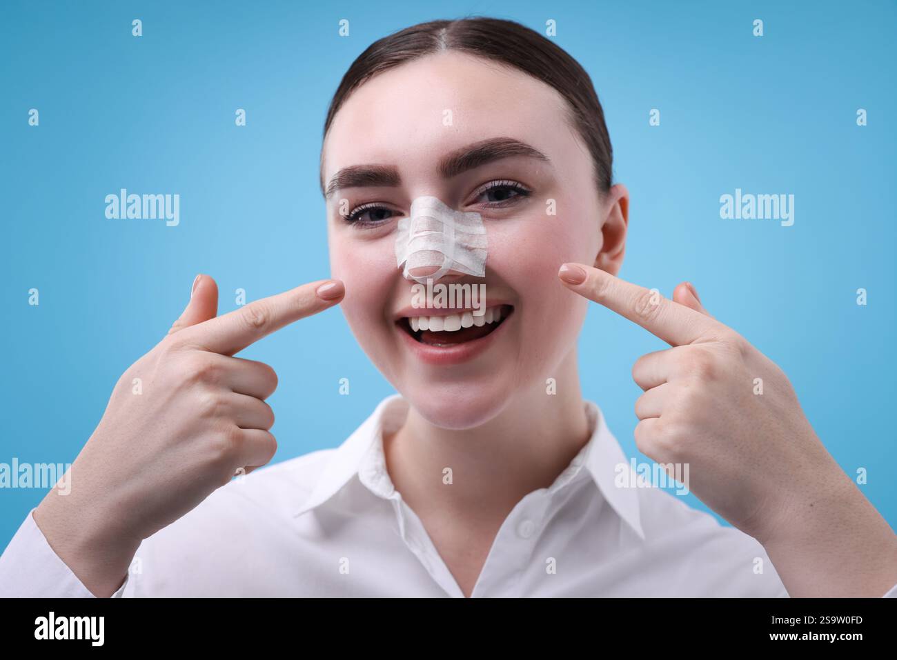 Woman with medical bandage on her nose after plastic surgery operation ...