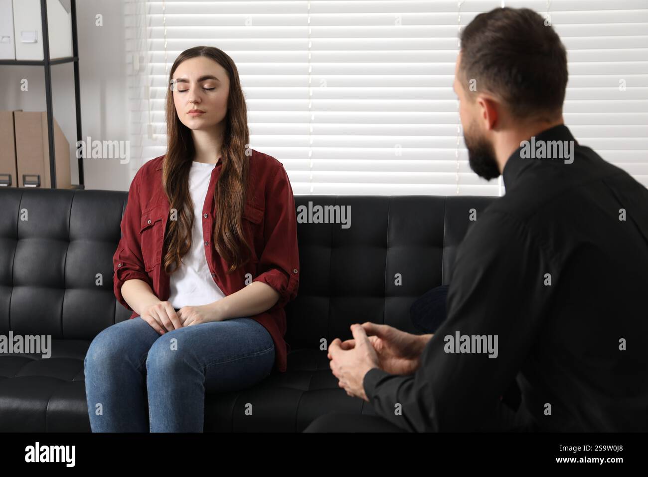 Psychologist working with patient during hypnosis session indoors Stock ...