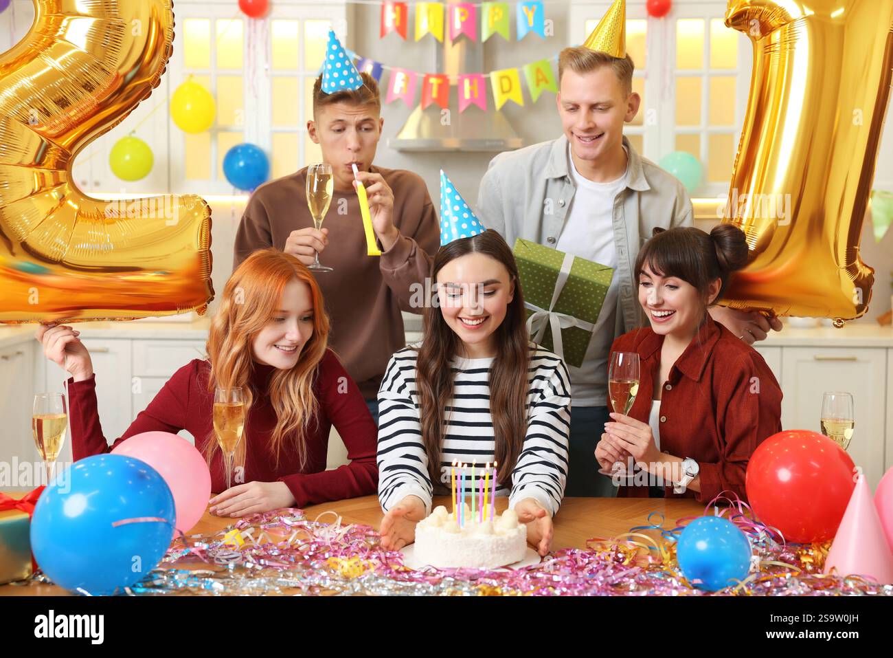 21st birthday. Group of happy friends with tasty cake having coming of ...