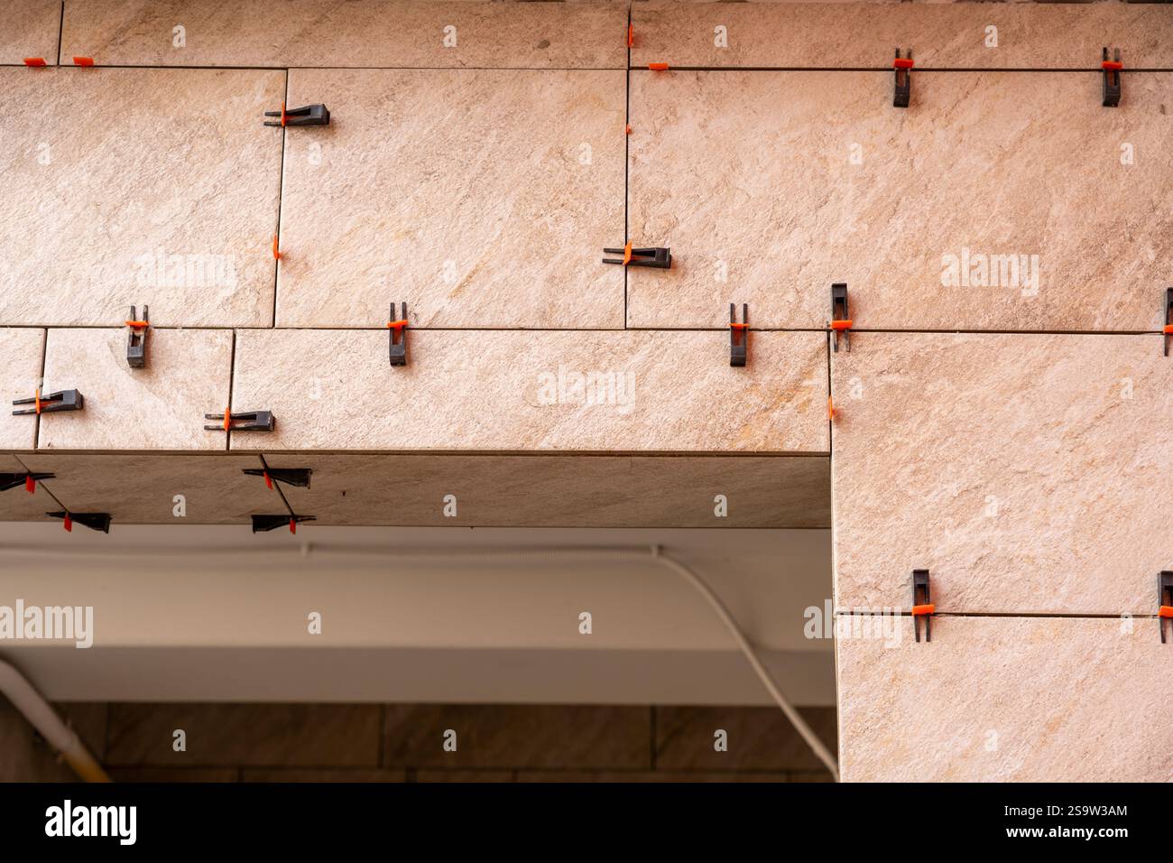 Tile leveling system with plastic clips and wedges, shot while the tile ...