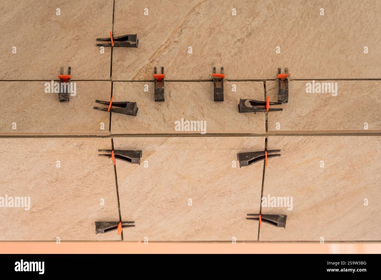 Tile leveling system with plastic clips and wedges, shot while the tile ...