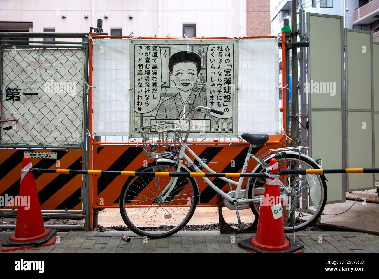 Cloth poster for Akabane's Miyazawa Construction company on the fence ...