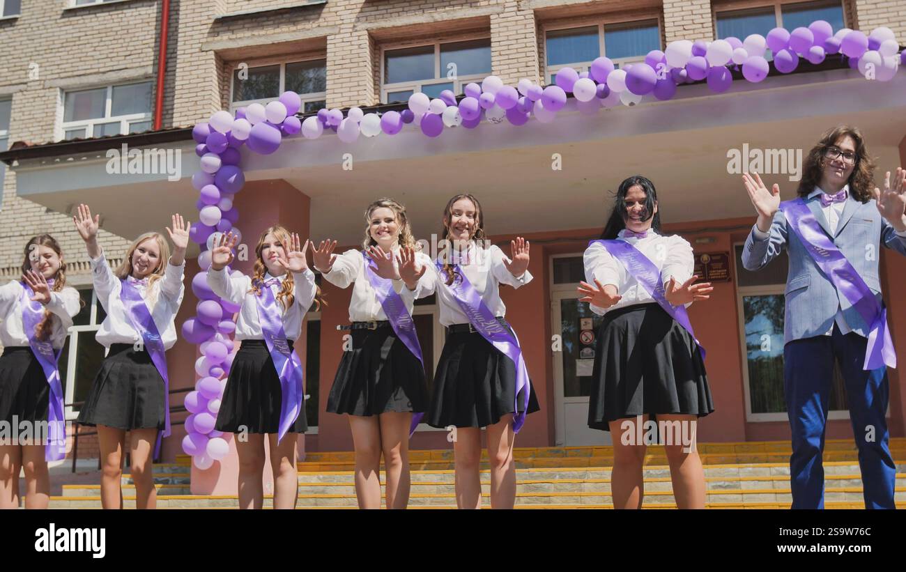Happy graduates waving goodbye on their last day of school, donning ...