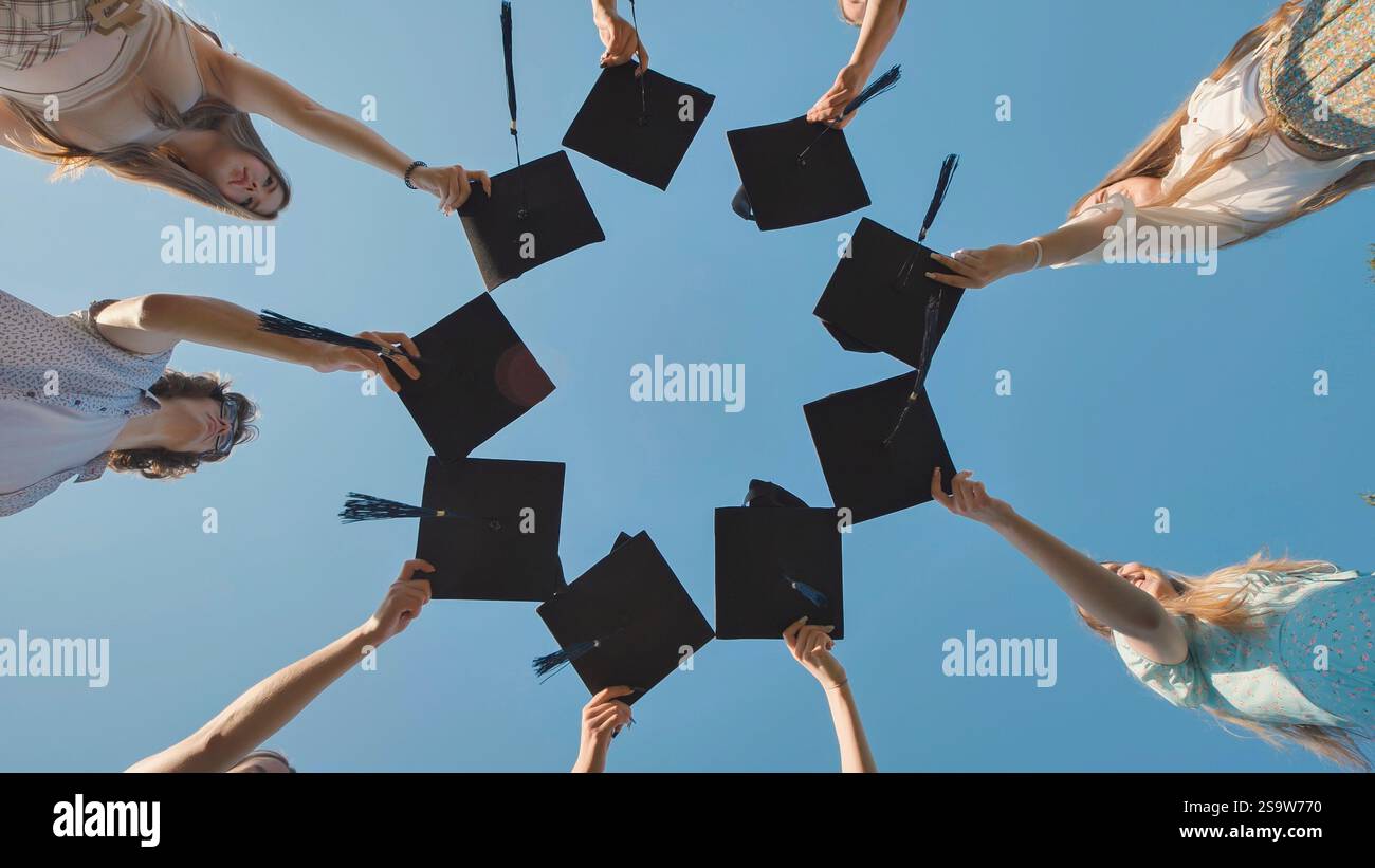 Group of cheerful graduates celebrating their graduation by forming a ...