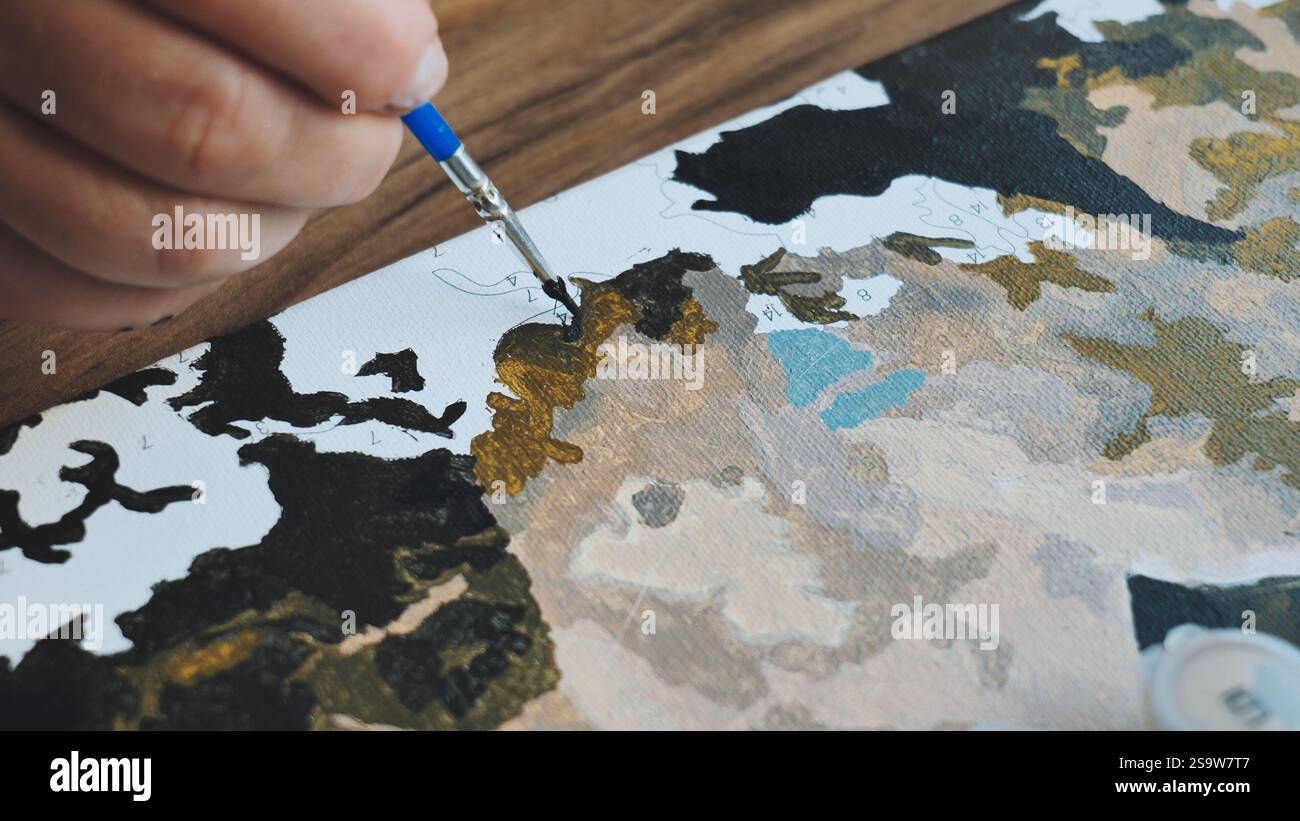 Hand carefully coloring pre marked canvas sections, transforming ...