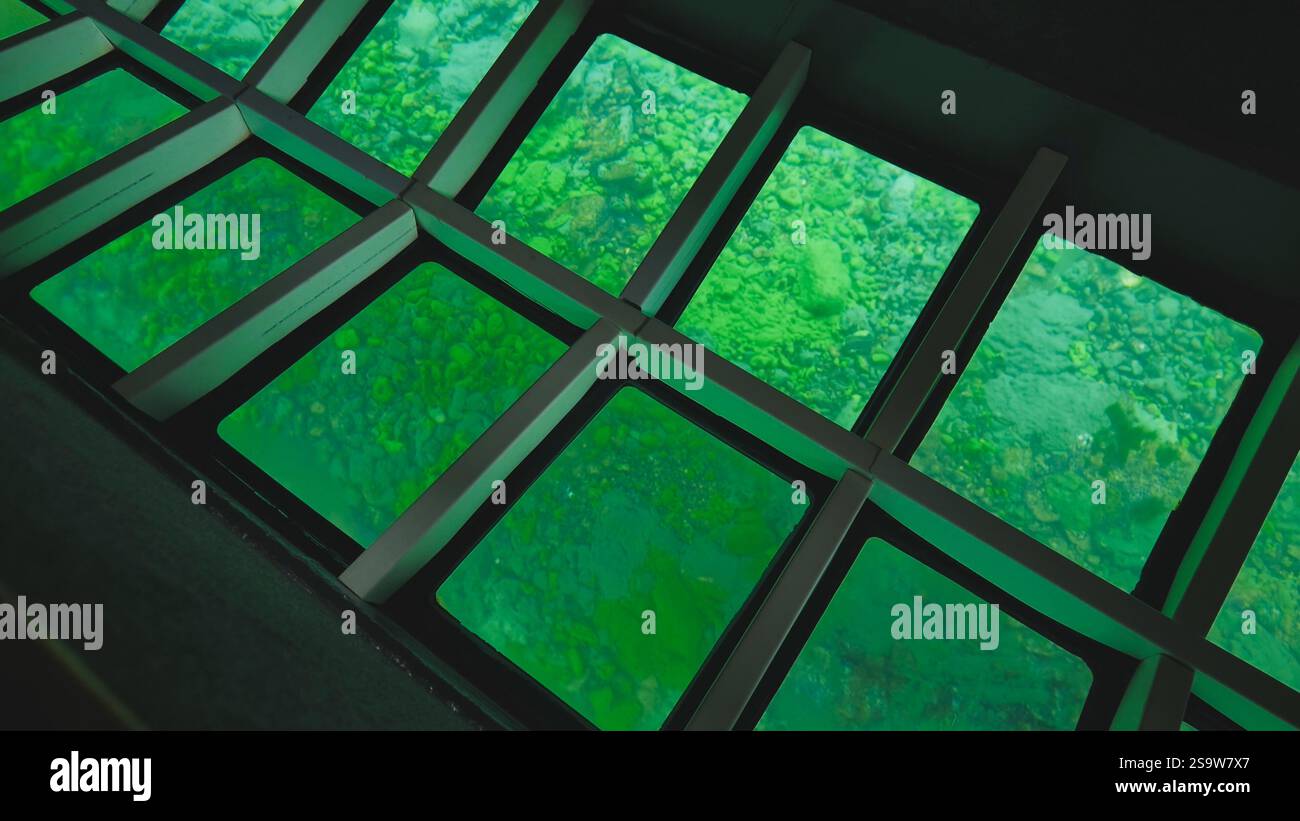 A boat with a glass bottom is sailing on Lake Baikal. Revealing emerald ...