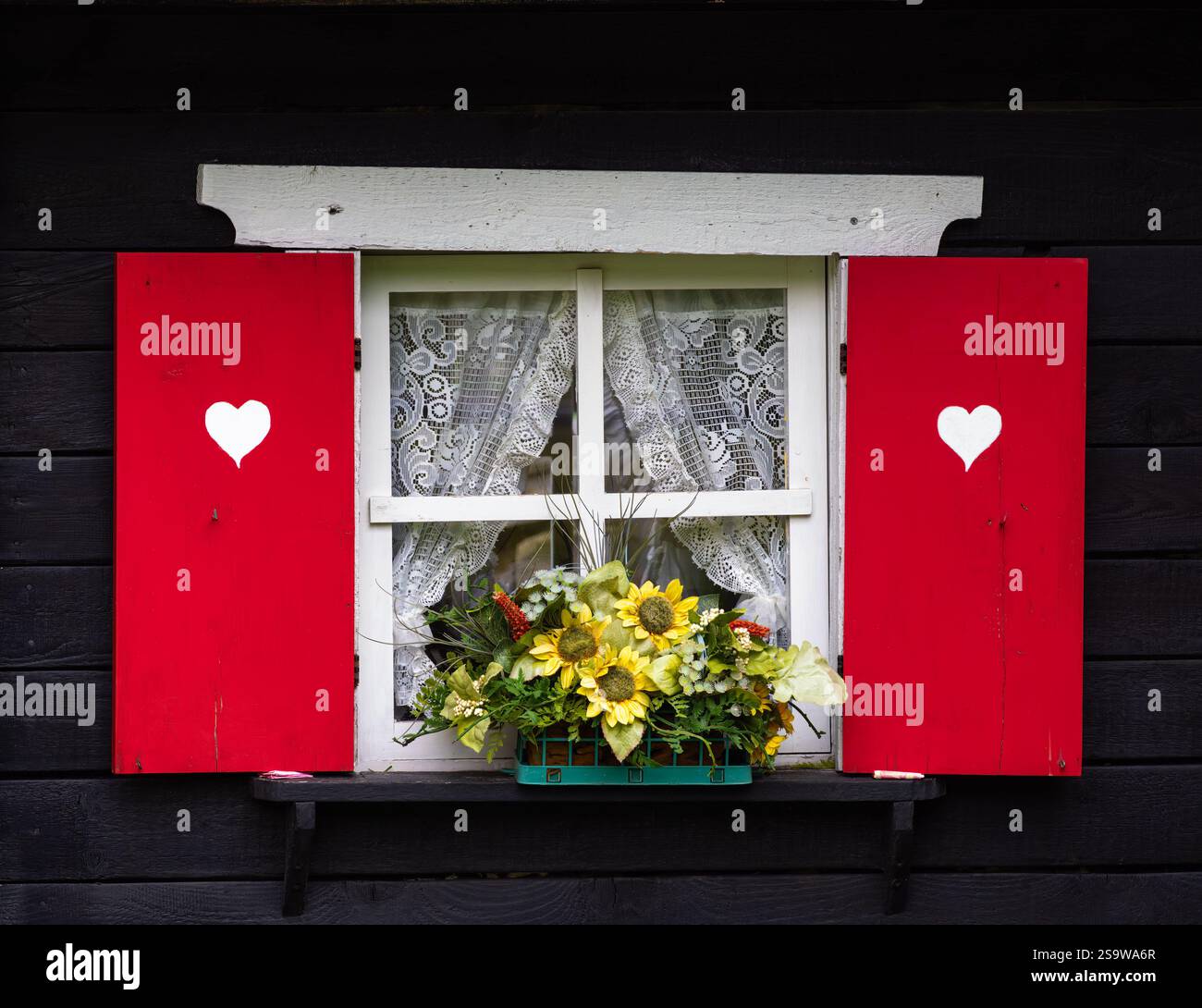 A charming window with red shutters featuring white heart shapes ...