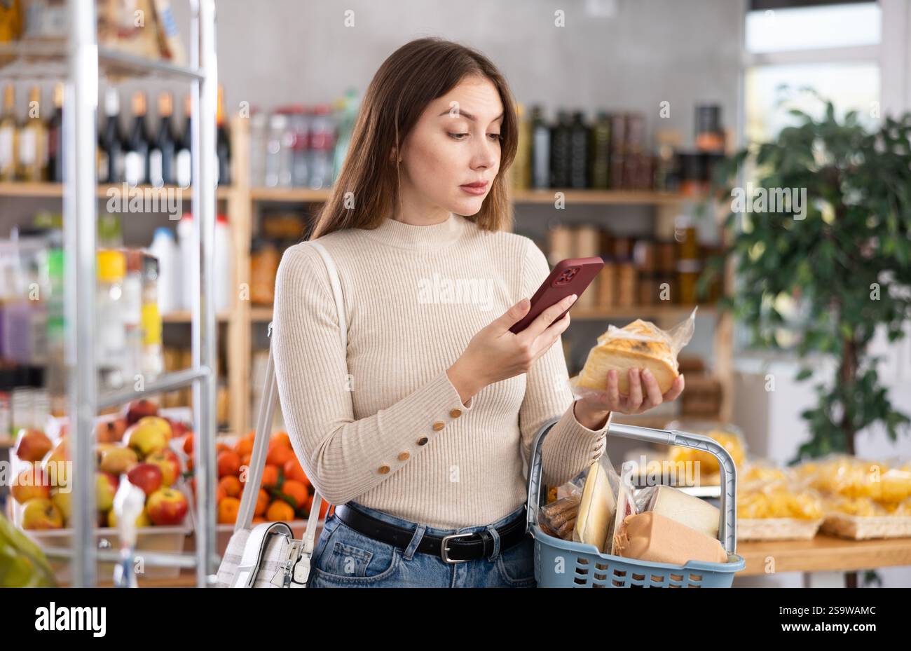 Girl scan QR-code on cheese in store Stock Photo - Alamy