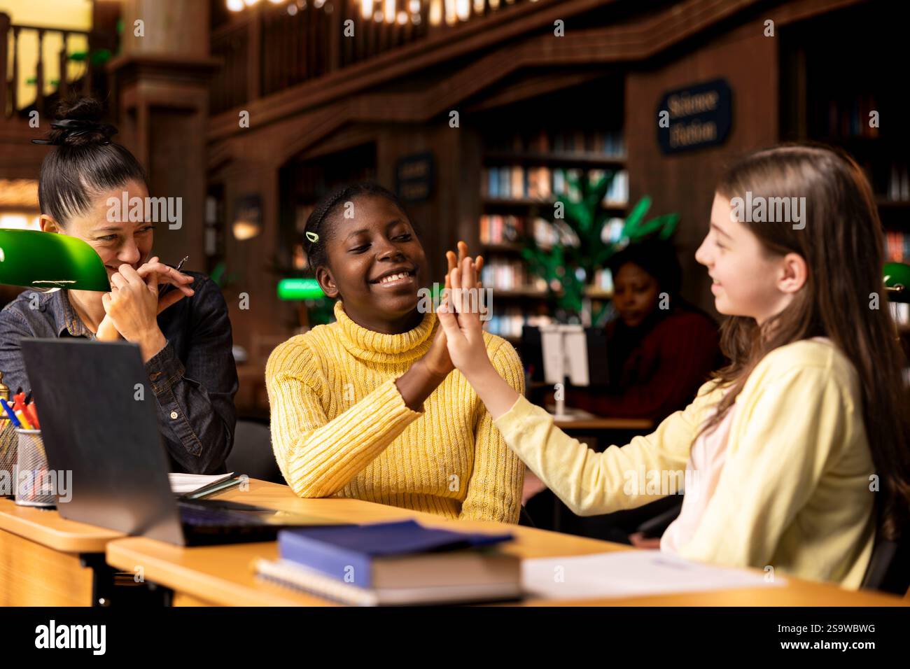 Satisfied teenagers students doing high five next to tutor in the ...