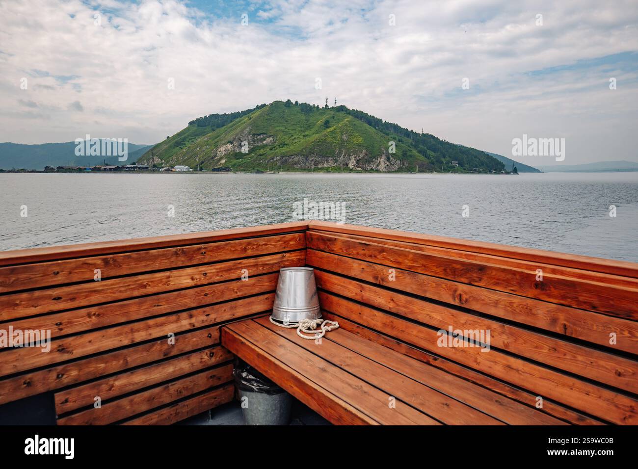 Metal bucket and rope on wooden deck of boat sailing on lake baikal ...