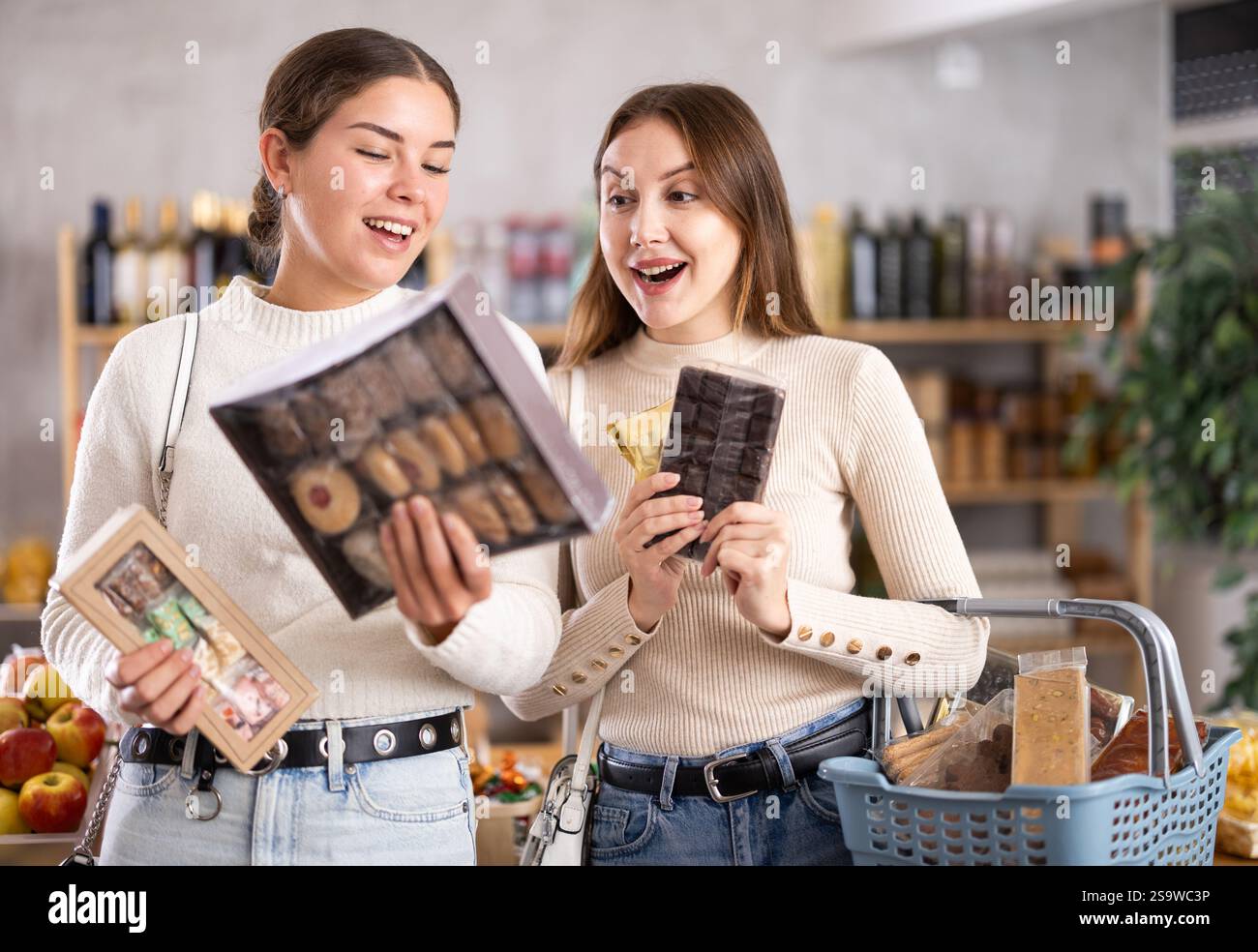 Two girls in store while shopping, choose sweets and chat sweetly Stock ...