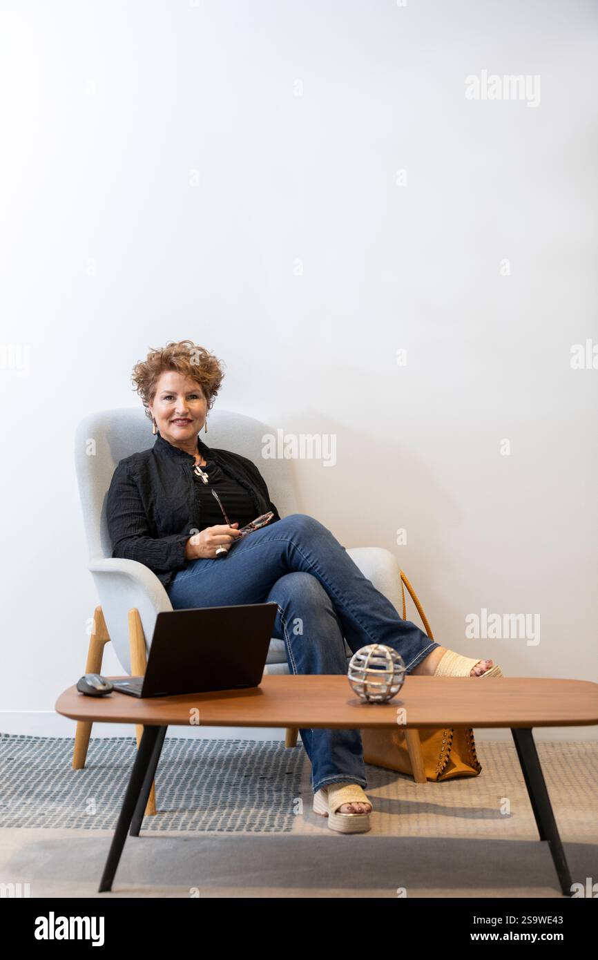 A professional woman sitting comfortably in a modern office setting ...