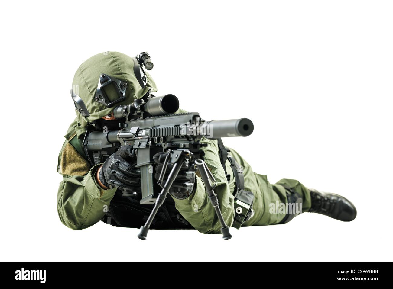 A soldier in a tactical uniform is lying down, aiming with a rifle ...