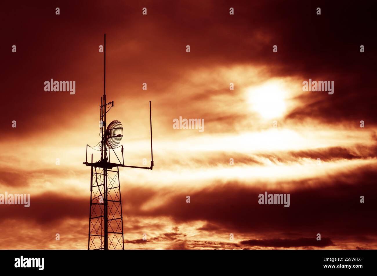 Silhouette shot of television and radio antenna pylon with cloudy sky ...