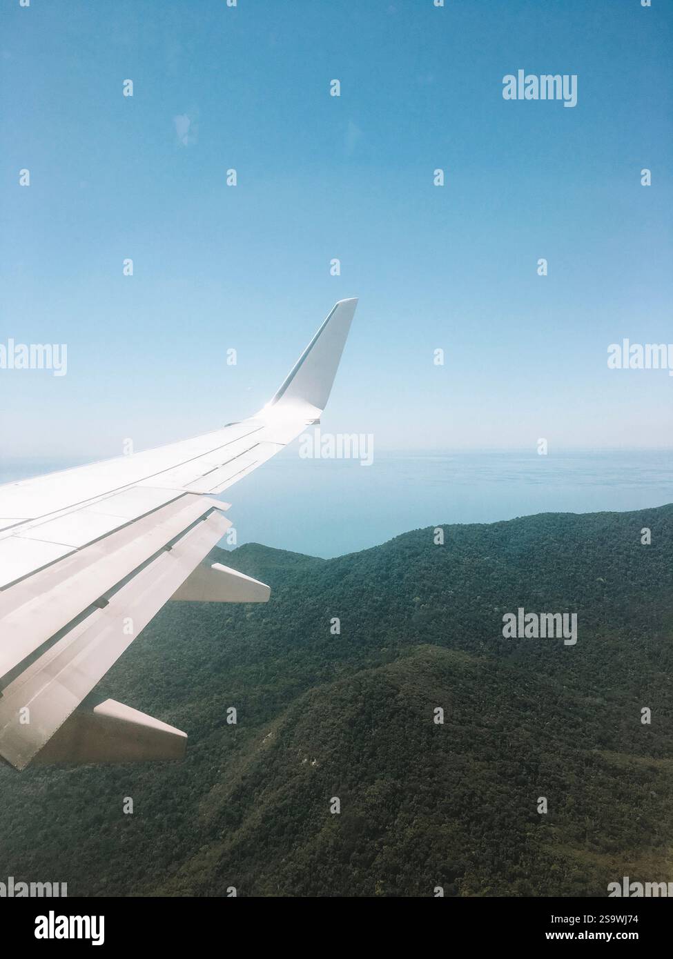 Stunning photographs of a plane wing flying over lush green mountains ...