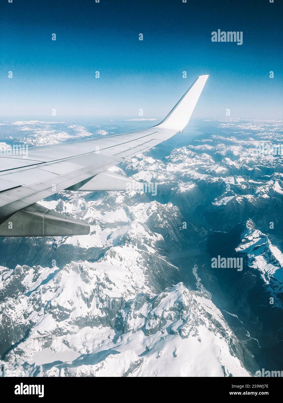 An aerial view from an airplane wing flying over the stunning snow-capped mountains of New ...