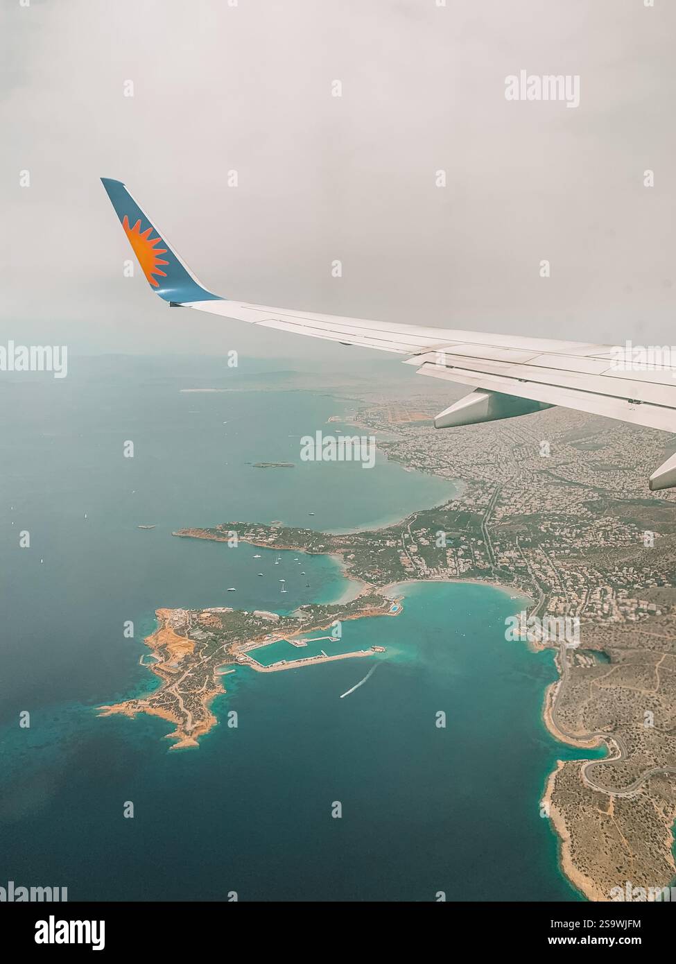 Striking photograph of an airplane wing soaring above Athens, Greece ...