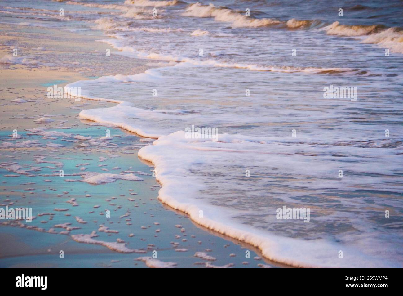 Stunning photograph of waves gently lapping the shore, reflecting the ...