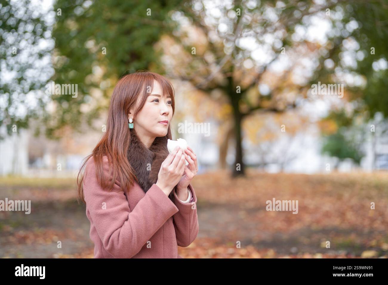 A park with beautiful autumn leaves. Japanese women with long hair in ...