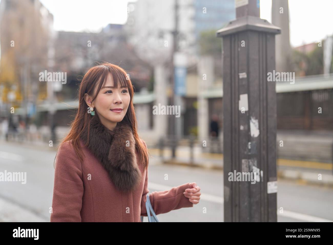A historic building in Hakata, Fukuoka, Japan. A Japanese woman with long hair in her 30s walks ...