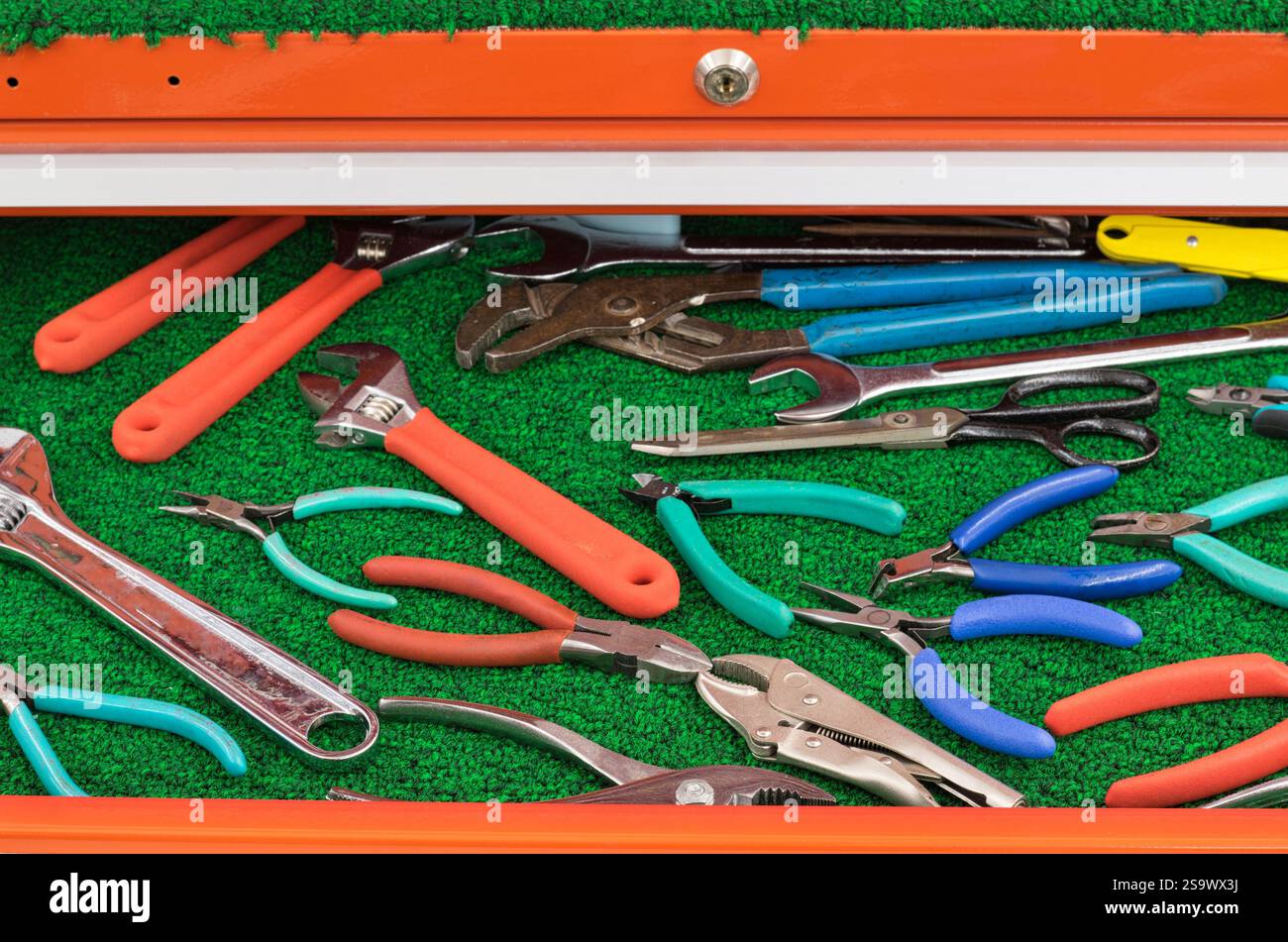 Assorted pliers wrench clamping tools displayed in open toolbox drawer ...