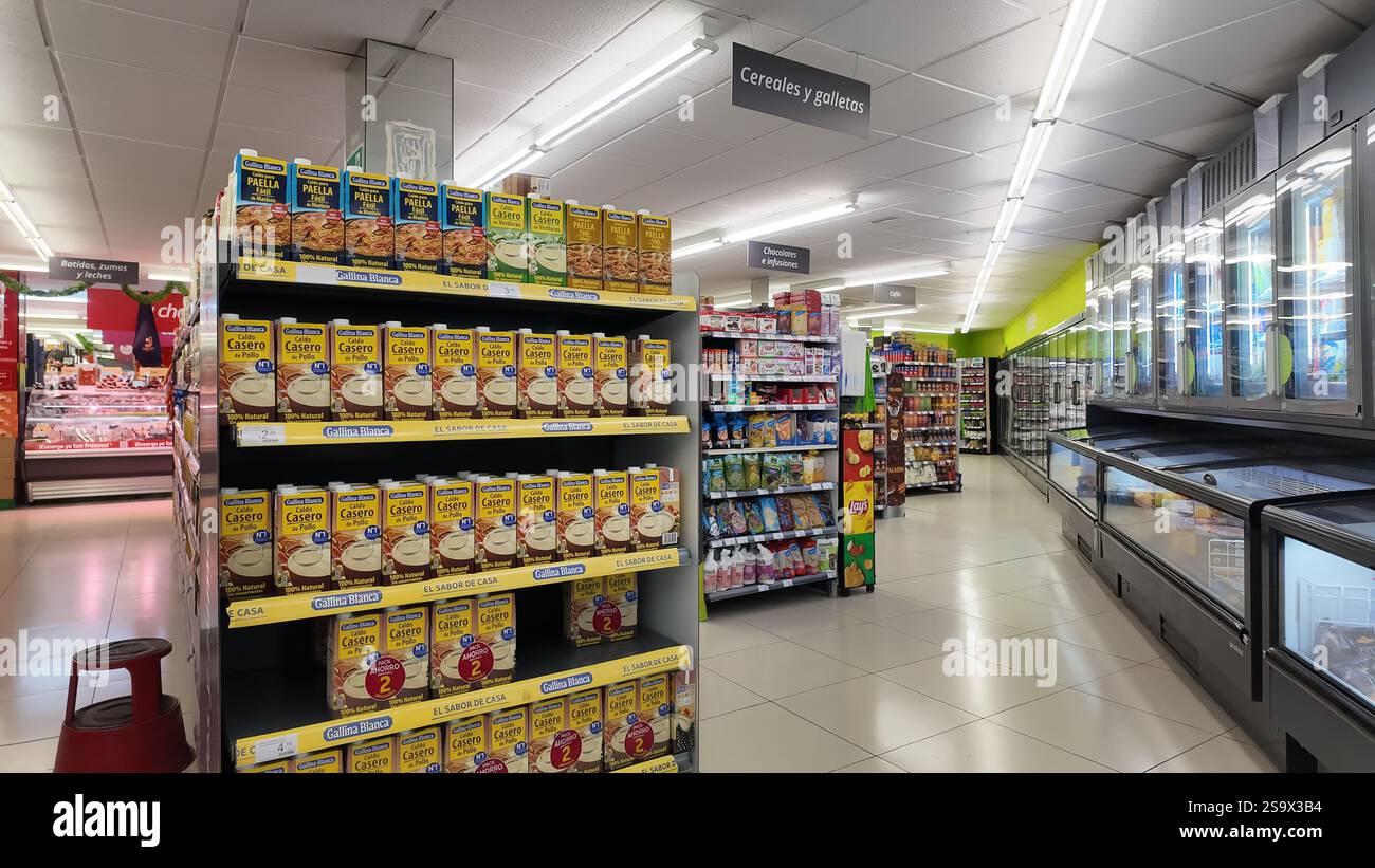 Inside a supermarket in Spain, one side features shelves stocked with ...