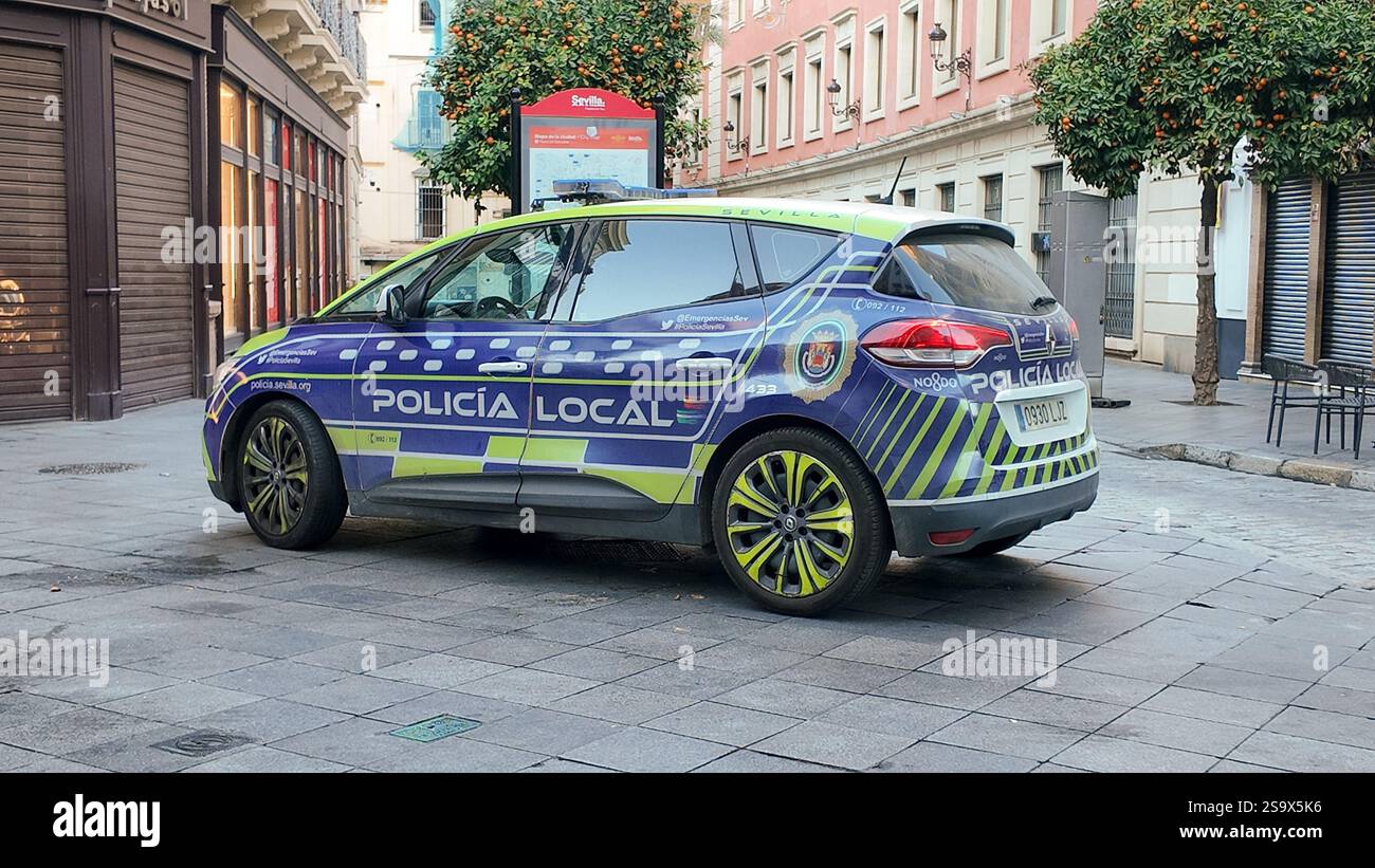 A blue and yellow police car is parked on a quiet and empty street in ...