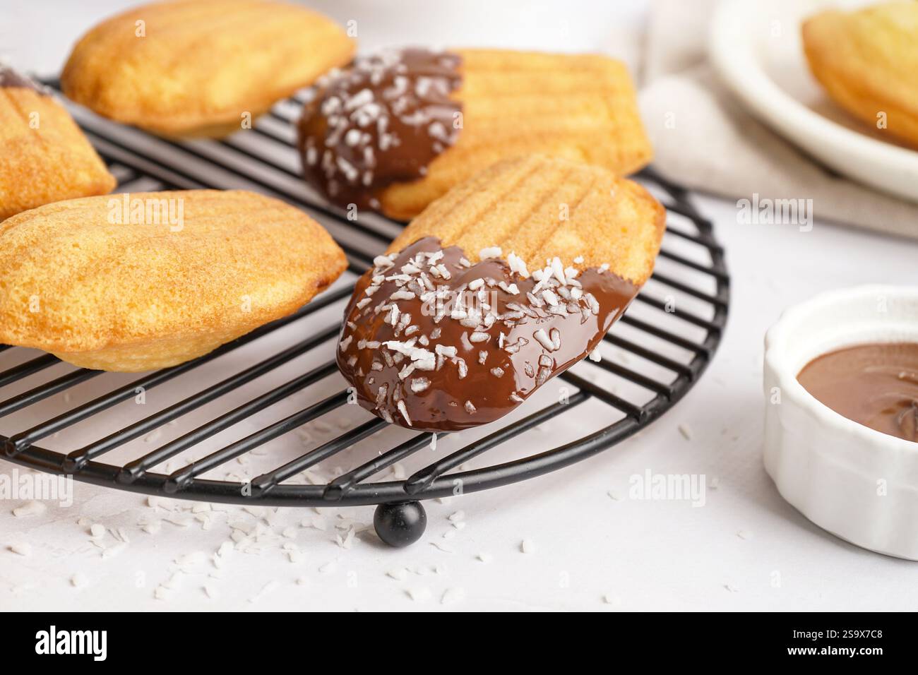 Grid of delicious madeleines and bowl of chocolate cream on white ...