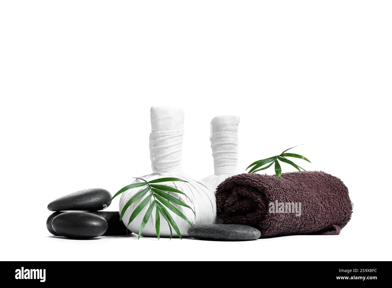 Herbal massage bags, spa stones, clean towel and palm leaves on white ...