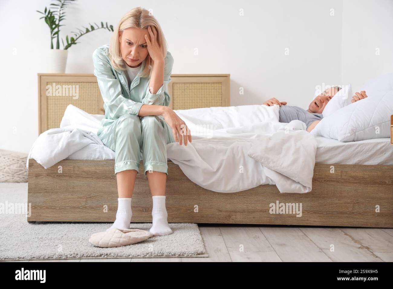 Mature woman suffering from her husband's snoring in bedroom Stock ...