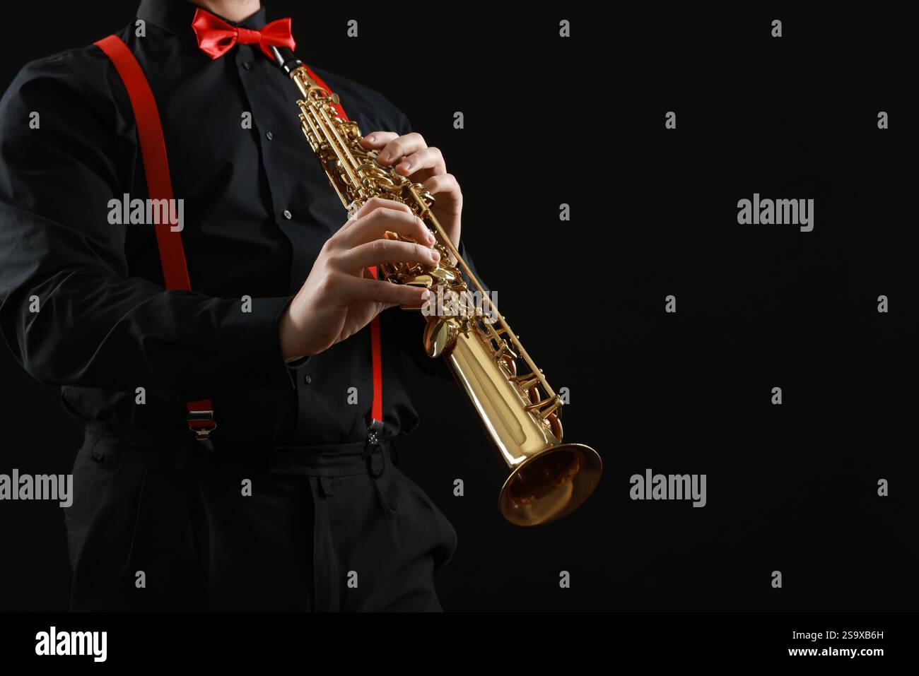 Professional musician playing soprano saxophone on black background ...