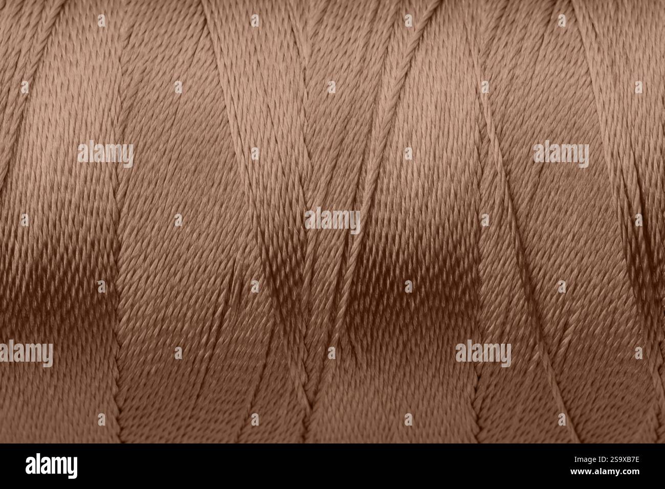 Sewing thread in mocha mousse shade, closeup. Trendy color of 2025 year ...