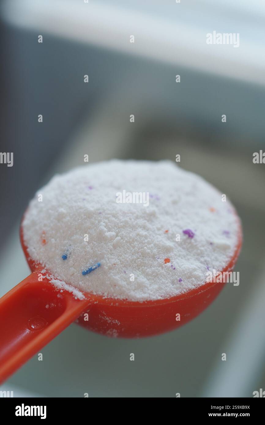 Measuring laundry detergent in a red scoop Stock Photo - Alamy