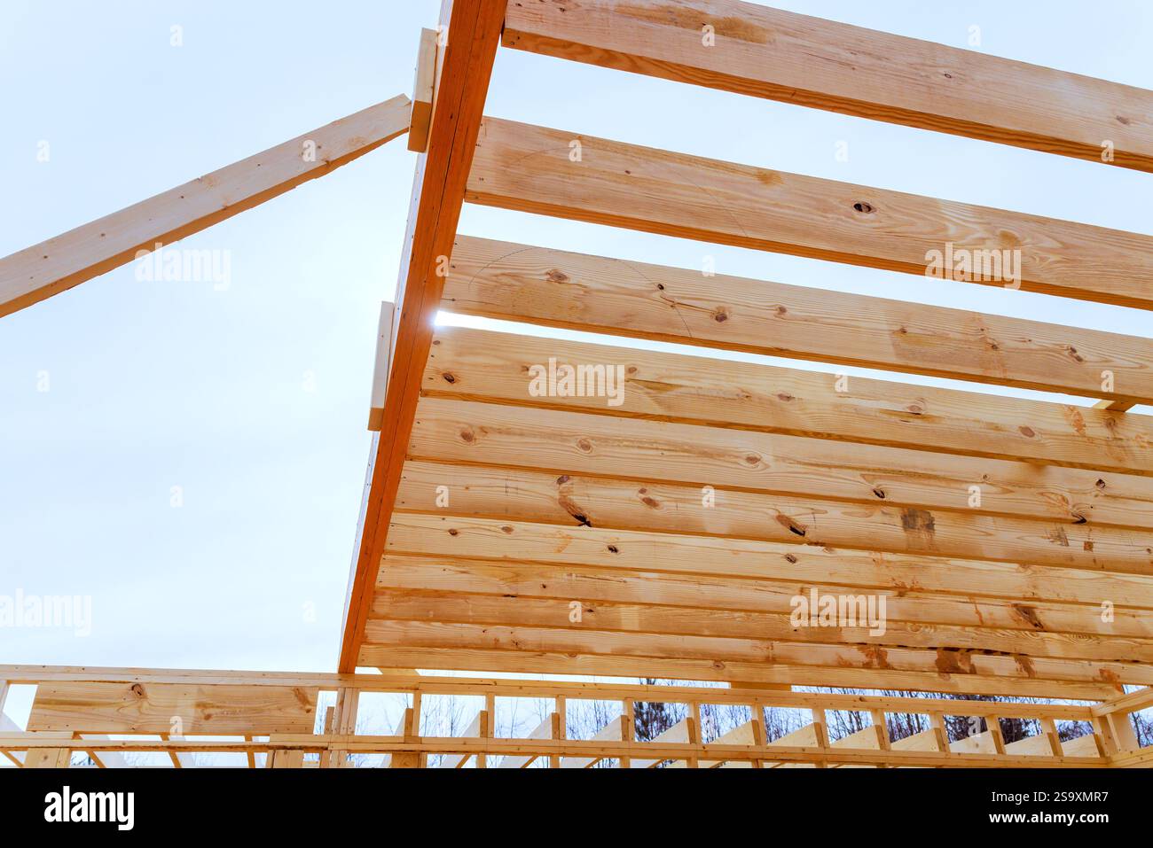 Constructing roof framework using wooden beams in suburban neighborhood ...