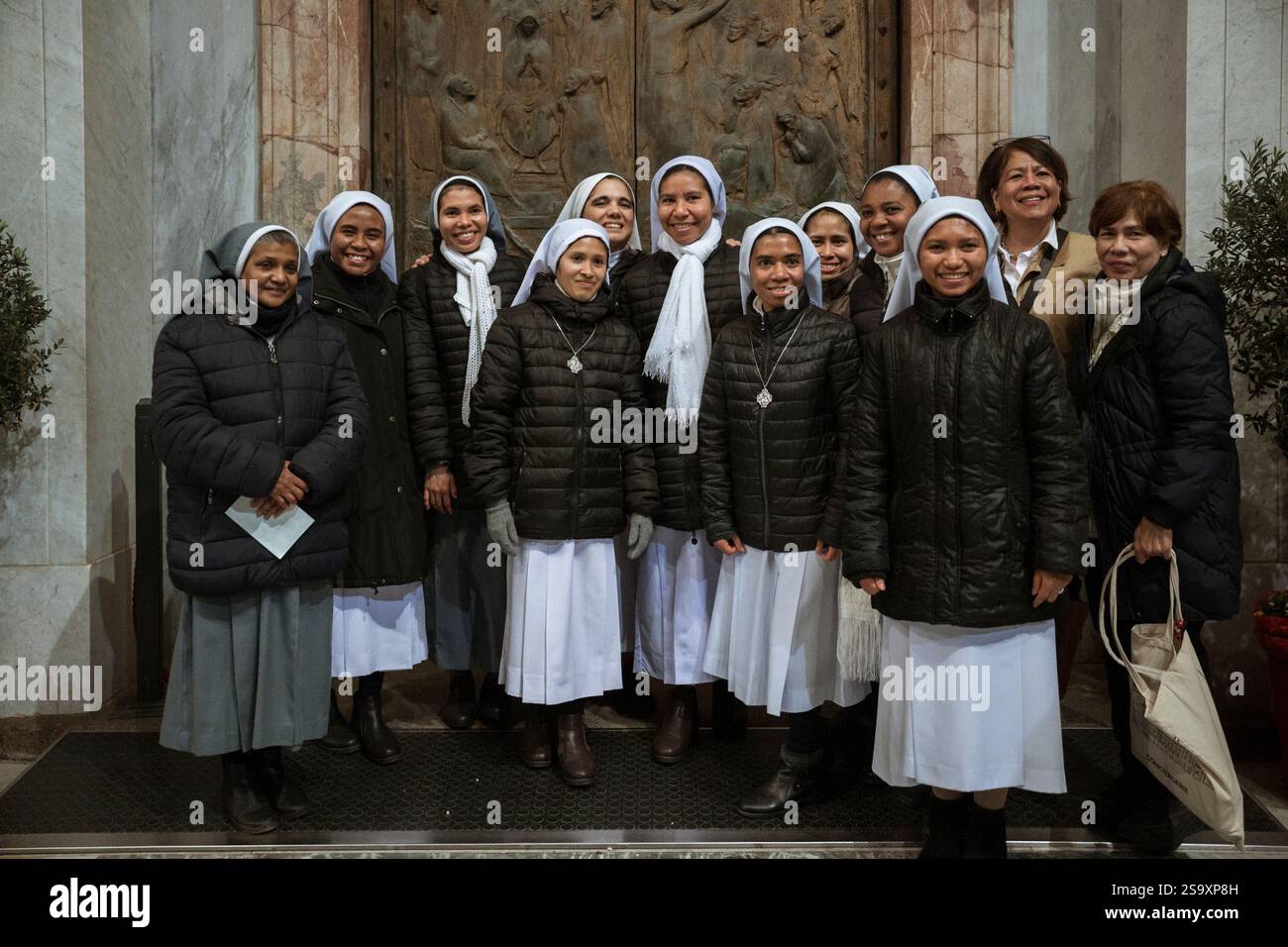 Rome, Italy. 25th Jan, 2025. A group of nuns take pictures at the holy ...