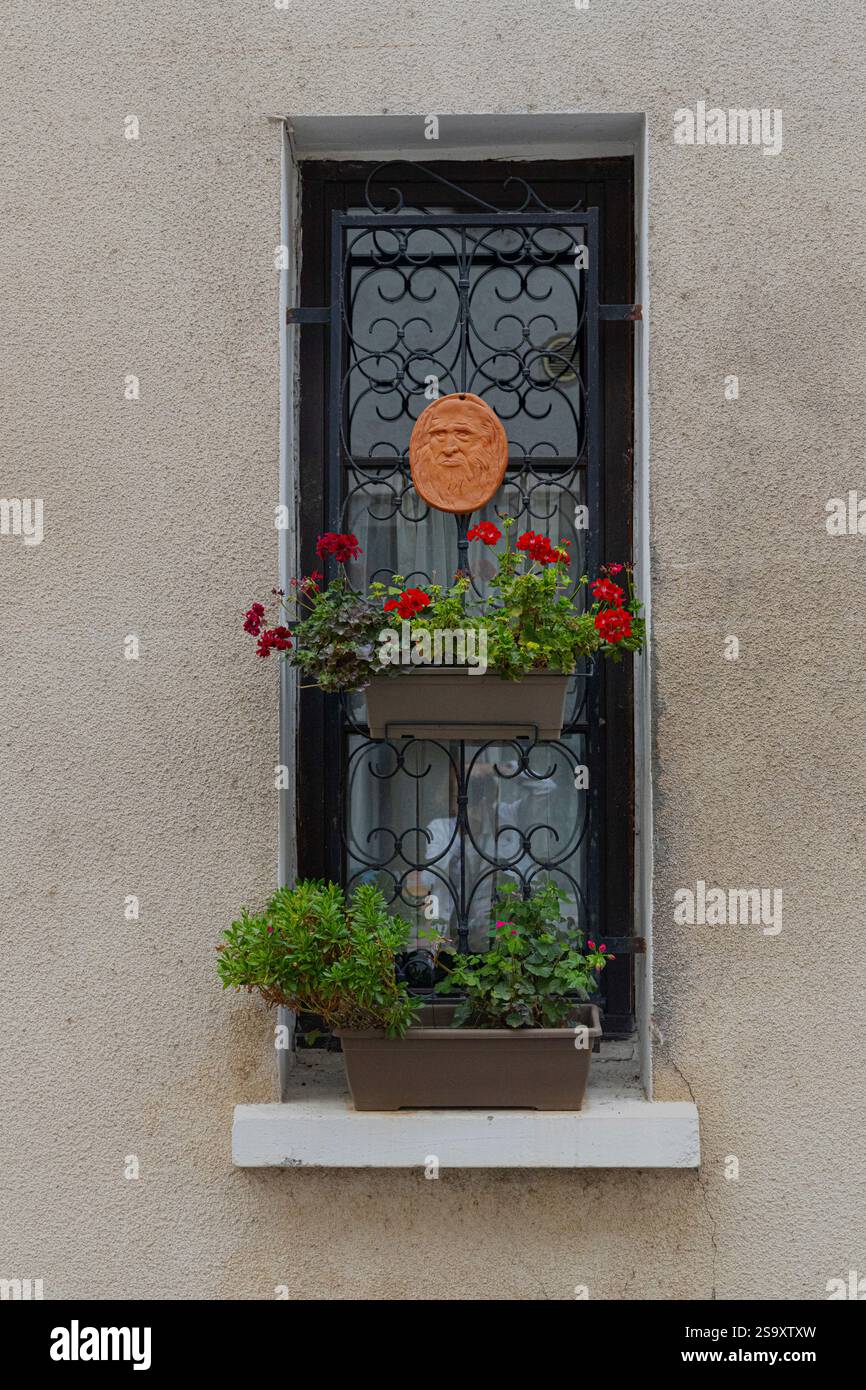 Window on a home in Amboise, France. Decorative wrought iron and flower ...