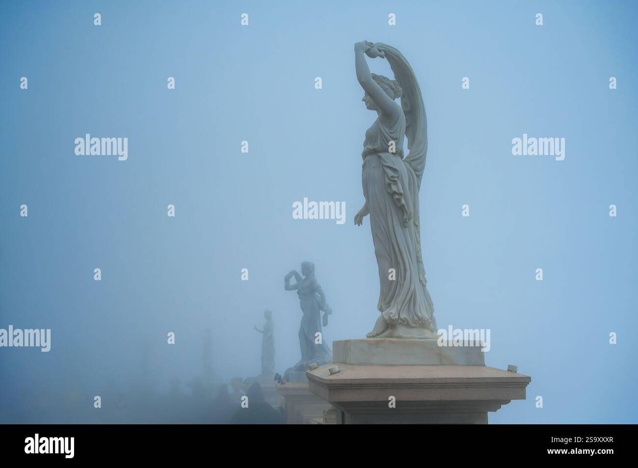 A marble statue of an ancient Roman or Greek goddess in a garden in a ...