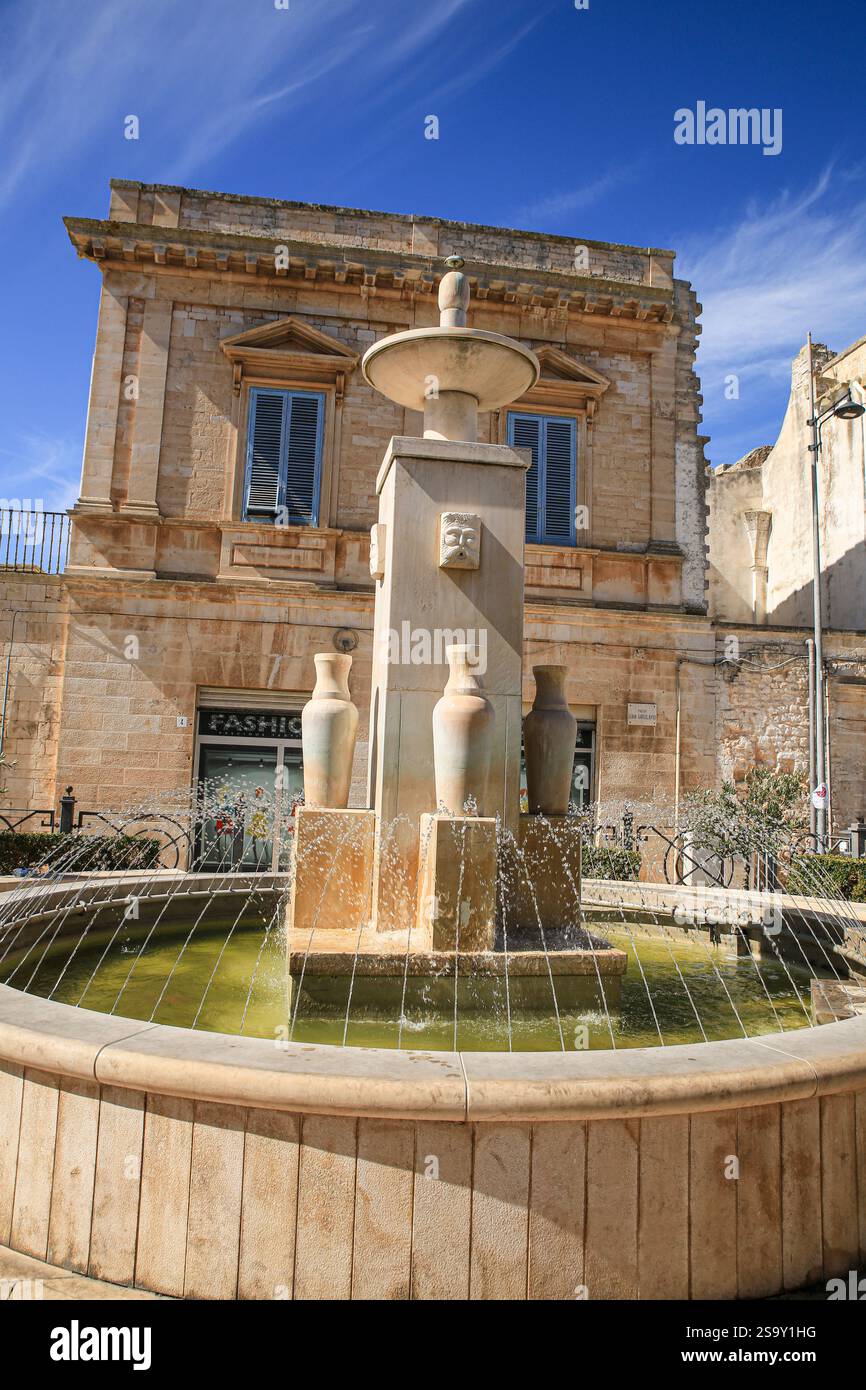 Alberobello, Italy. Piazza water fountain with Roman urns and face ...