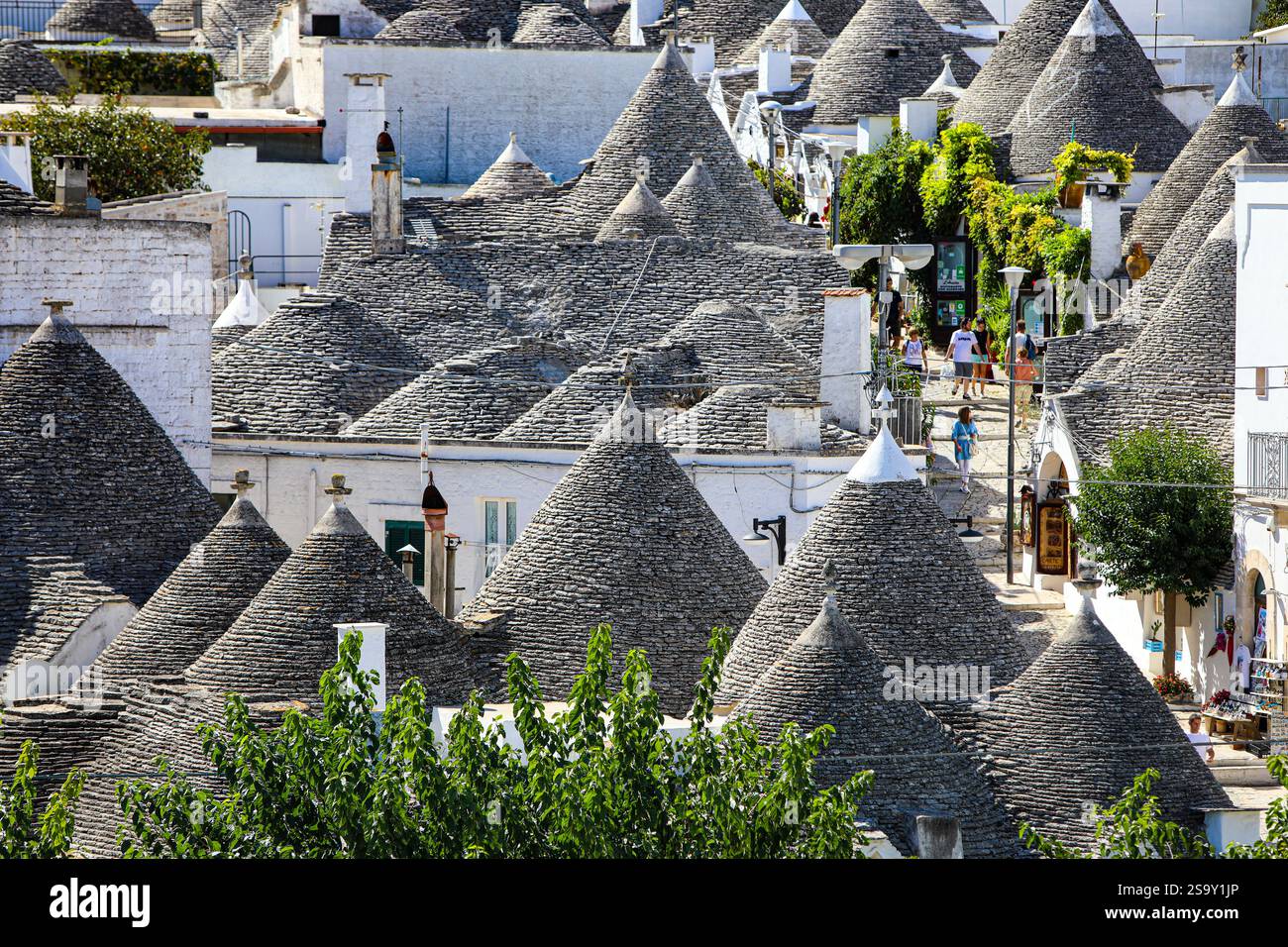 Arabella, Italy. Trulli cone shaped village with shoppers and tourists ...