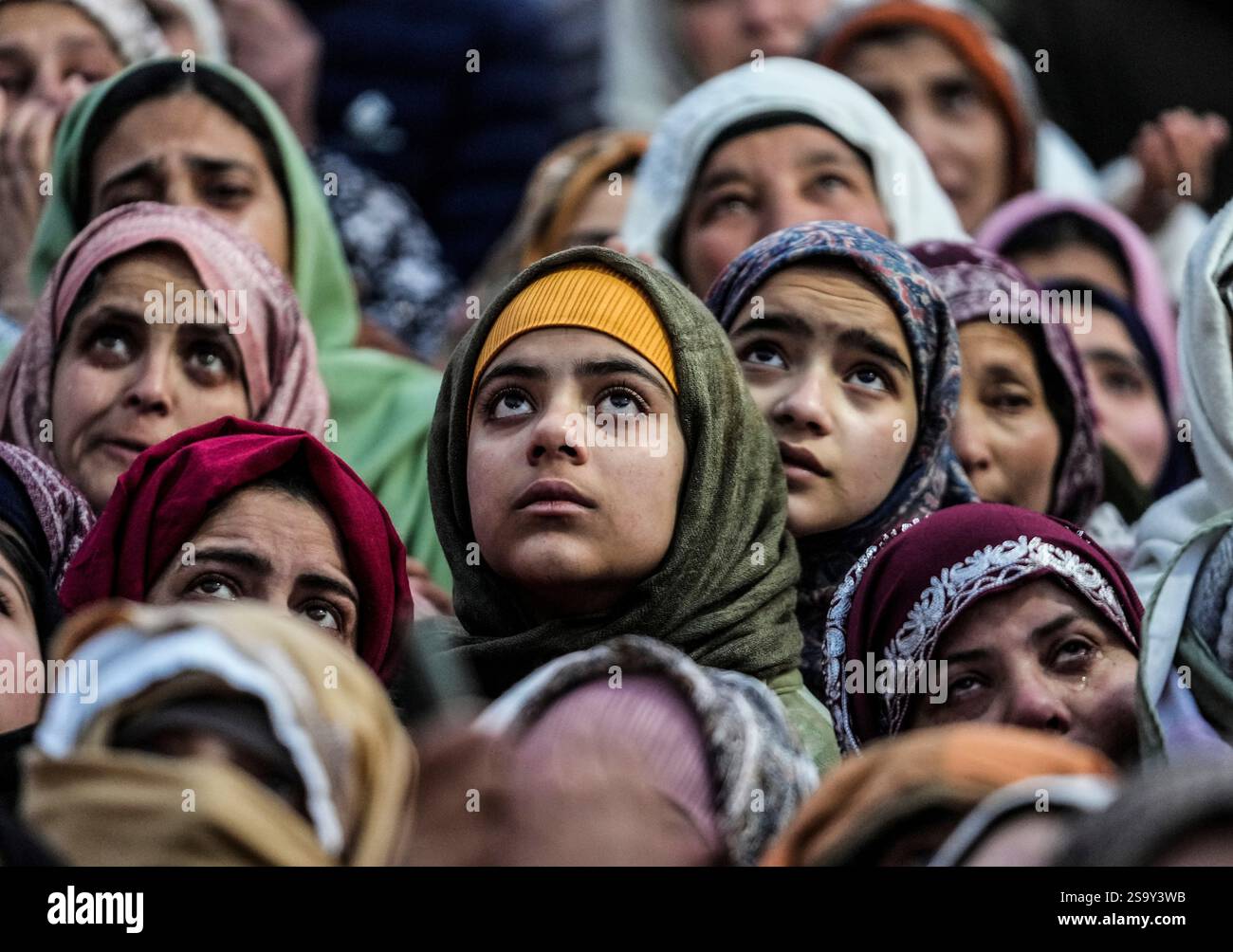 Kashmiri Muslim devotees look on and pray as a head priest displays a ...