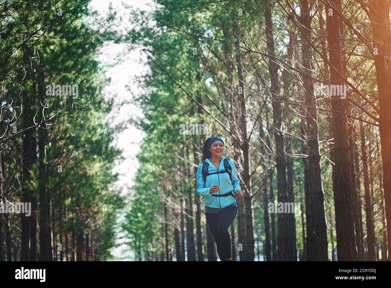 Trees, running and woman in forest with fitness, wellness and challenge ...