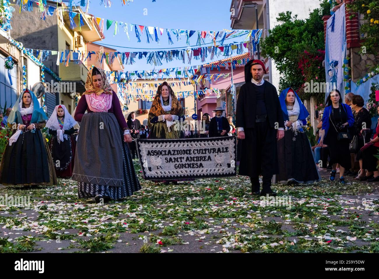 A group of traditionally dressed people walk through the streets in ...