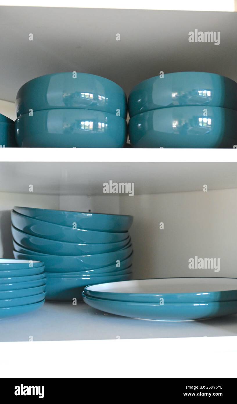 Teal plates on white shelves in kitchen cabinet, vertical shot Stock ...