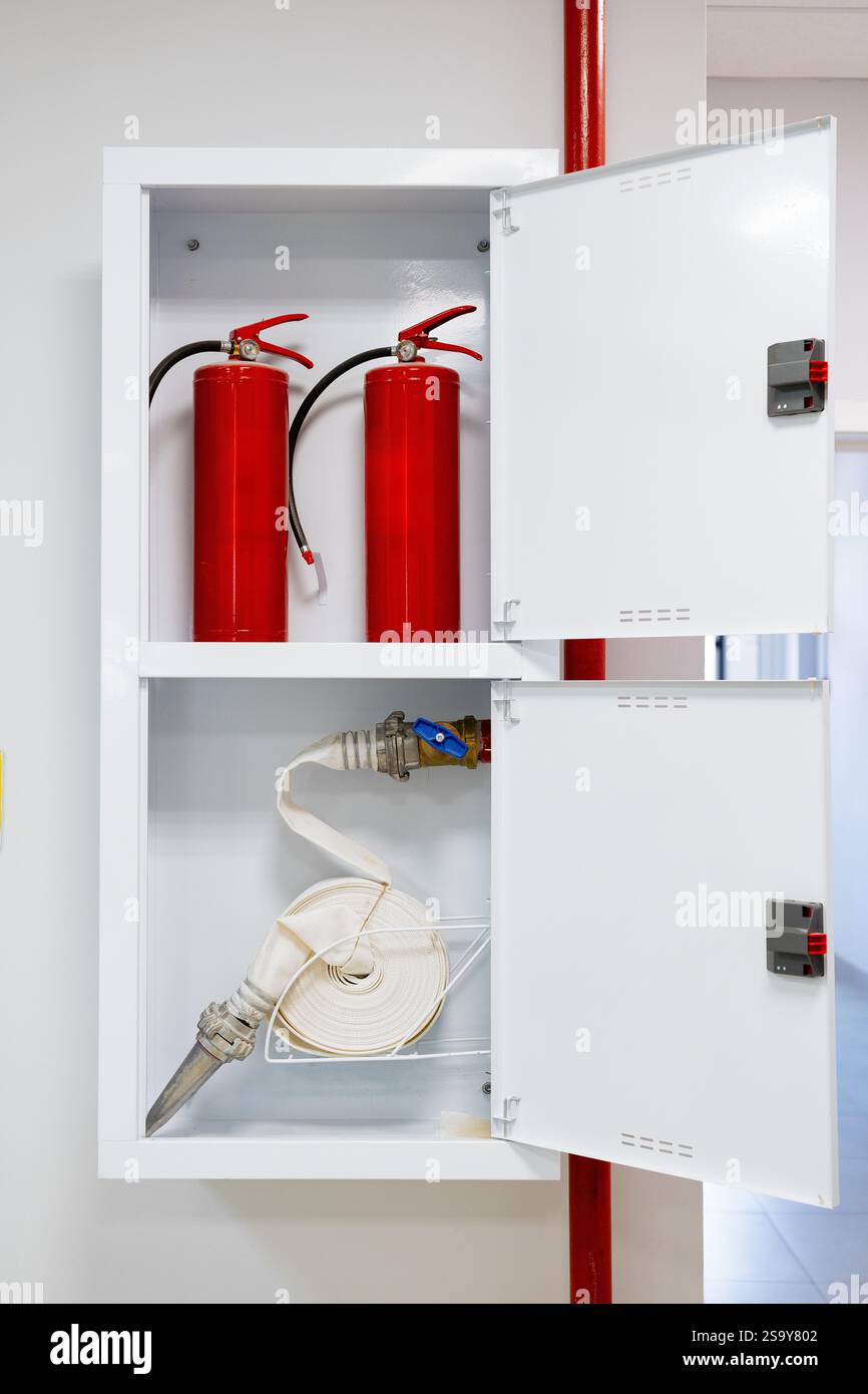 Storage cabinet containing fire extinguishers and hoses in a modern ...