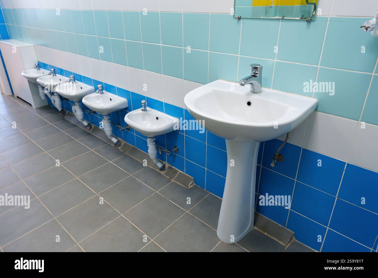 Clean and modern restroom featuring multiple sinks and urinals in a ...