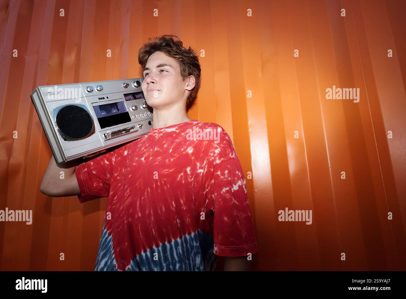 Carrying Retro Boombox Against Vibrant Orange Wall Stock Photo - Alamy