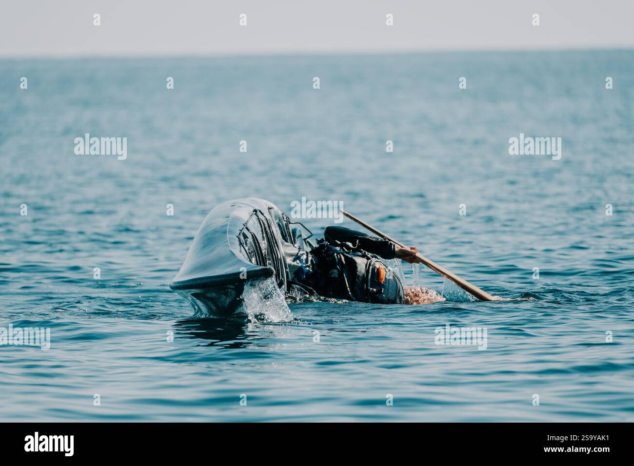 Diver, Sea, Boat: A diver with a speargun emerges from the water next ...