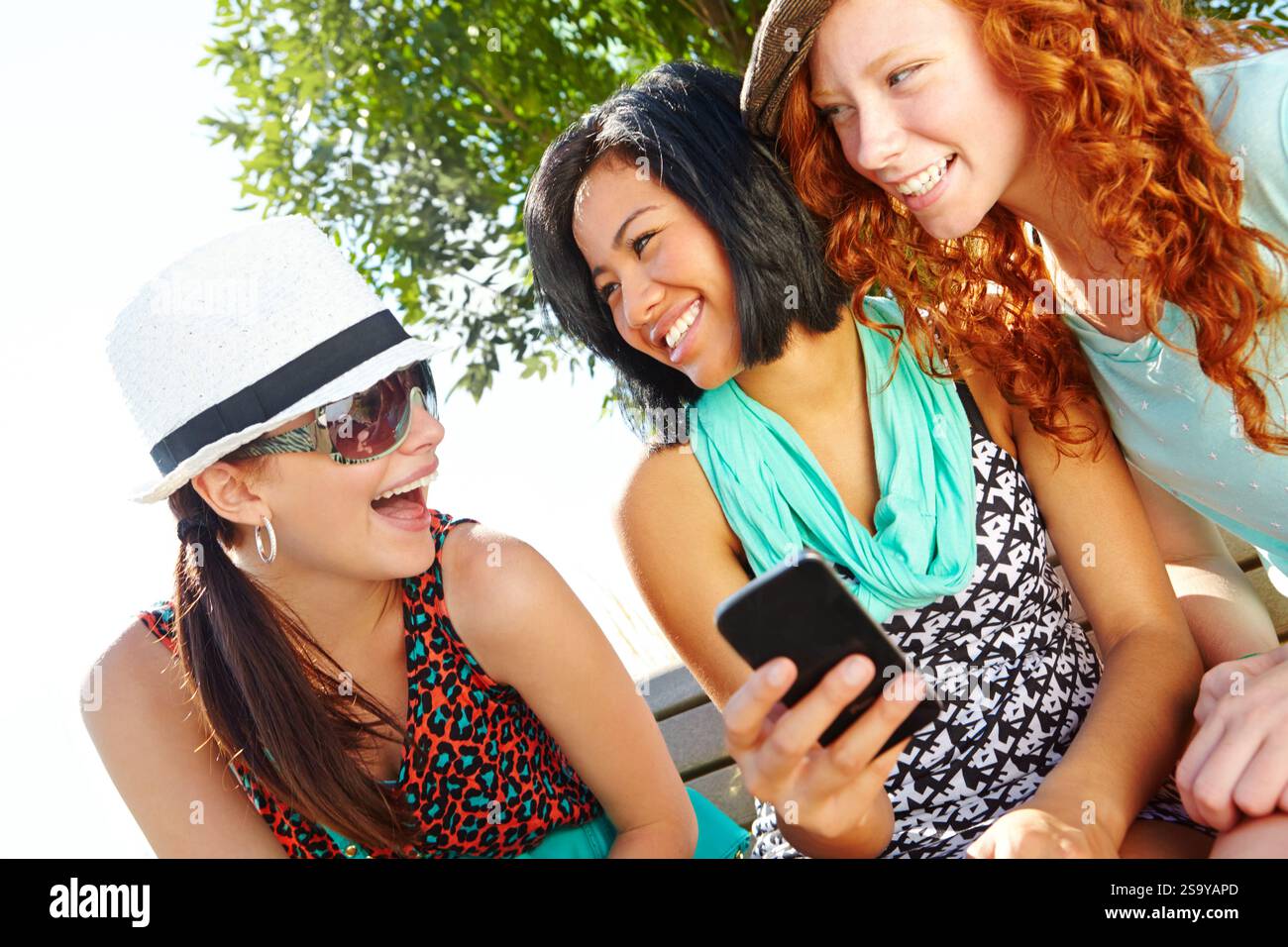 Women, park and phone with laugh, reading together and comic meme on ...