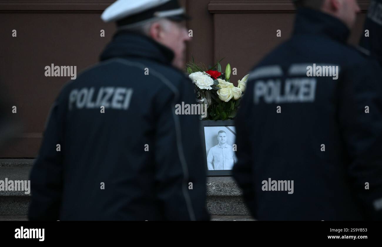 Dresden, Germany. 28th Jan, 2025. A portrait and flowers stand in front ...