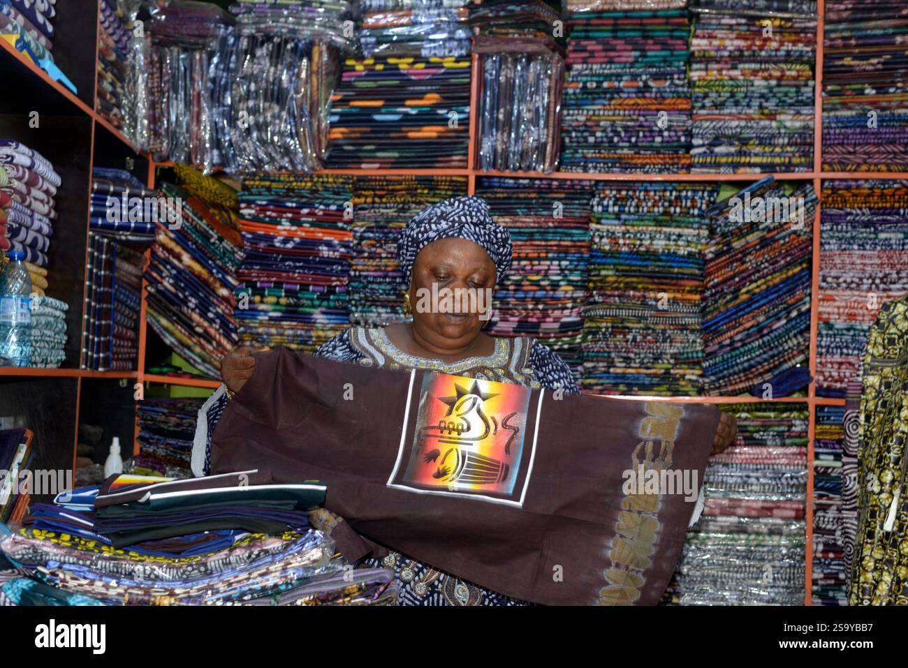 Madam Yemi Badmos Arranges Fabrics In Her Adire Shop During The 2025